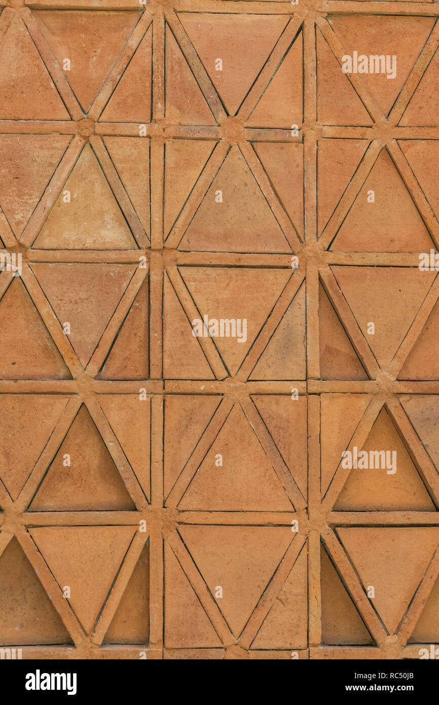 Isolated shot of a red stone wall with a triangular pattern, in Oaxaca ...