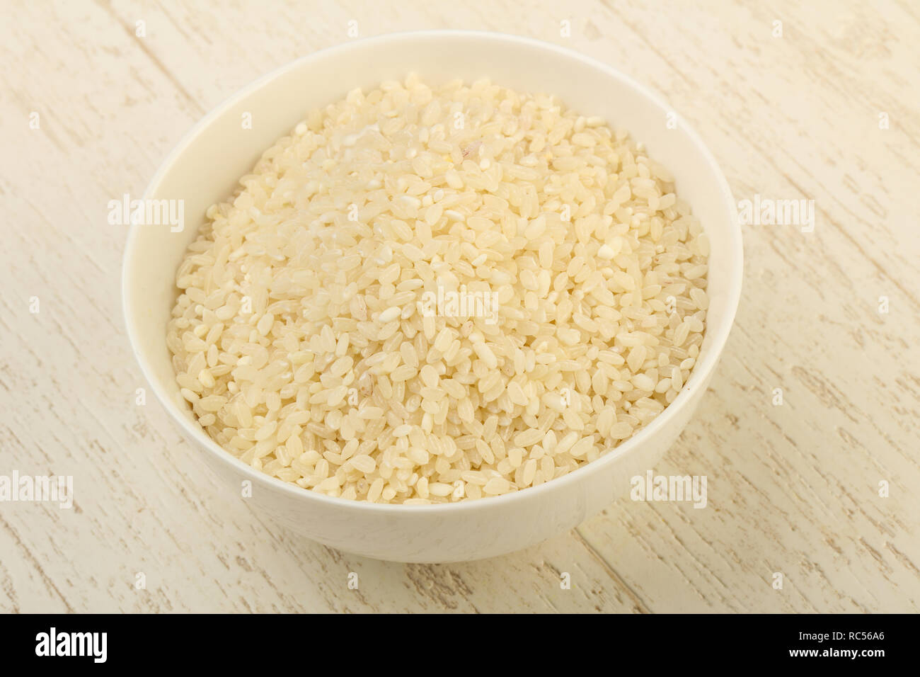 Raw rice heap in the bowl - ready for cooking Stock Photo - Alamy