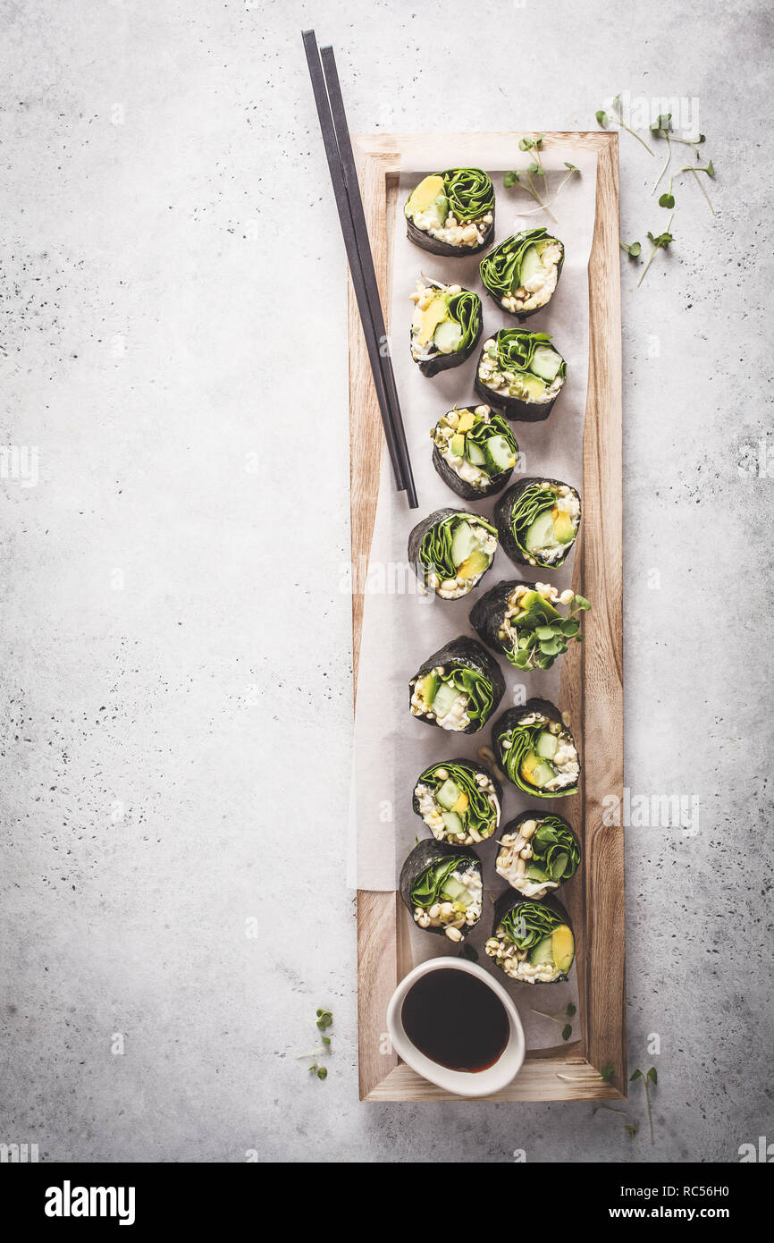Vegan green sushi rolls with avocado, sprouts, cucumber and nori on a ...