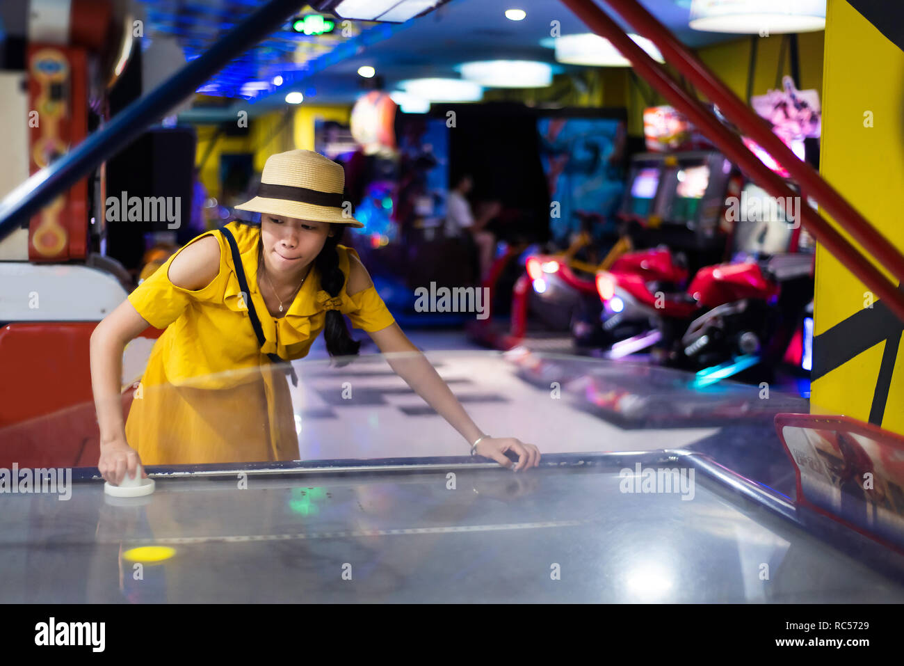 Woman playing games at arcade entertainment center Stock Photo - Alamy