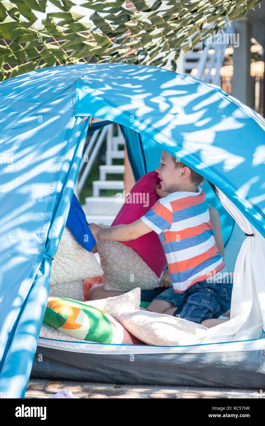 cute boys playing with pillow inside tent at backyard Stock Photo - Alamy