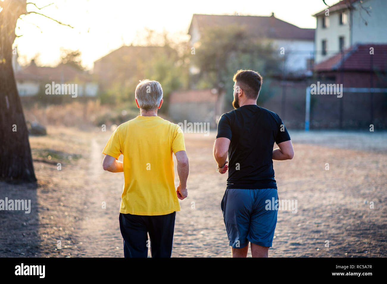 Men running in the park at sunset Stock Photo - Alamy