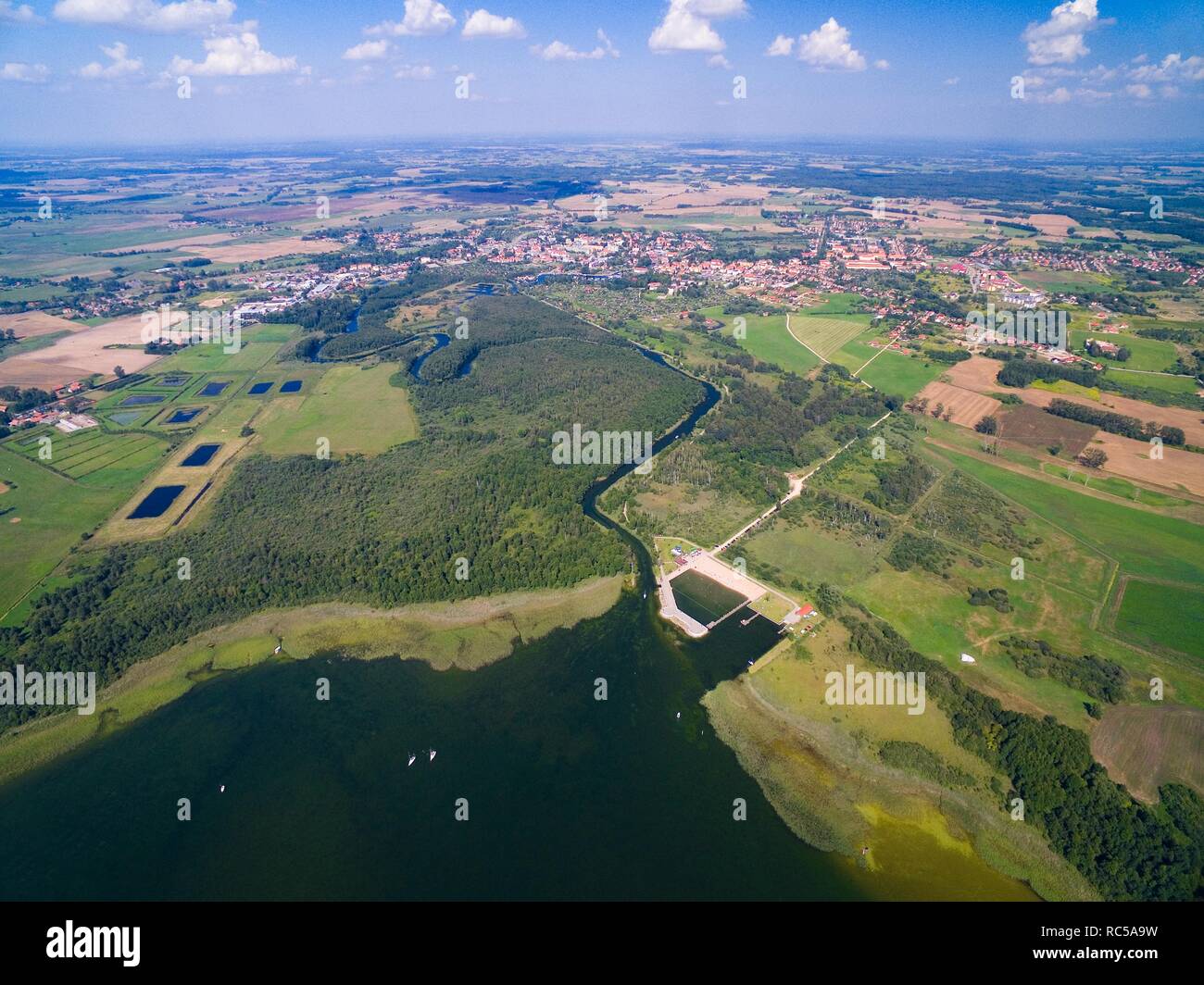 Aerial view of yachts sailing on Mamry Lake, concrete quay and town ...