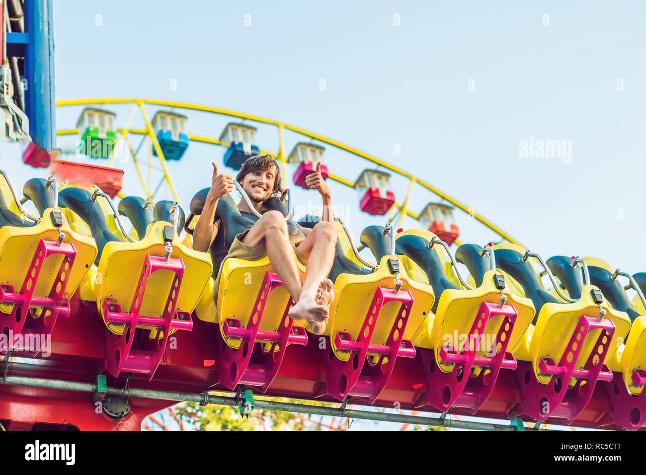 Beautiful, young man having fun at an amusement park Stock Photo - Alamy