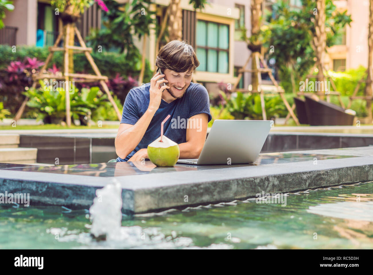Young freelancer working on vacation next to the swimming pool Stock ...