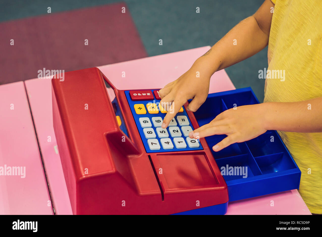 The boy plays with the children's cash register Stock Photo - Alamy