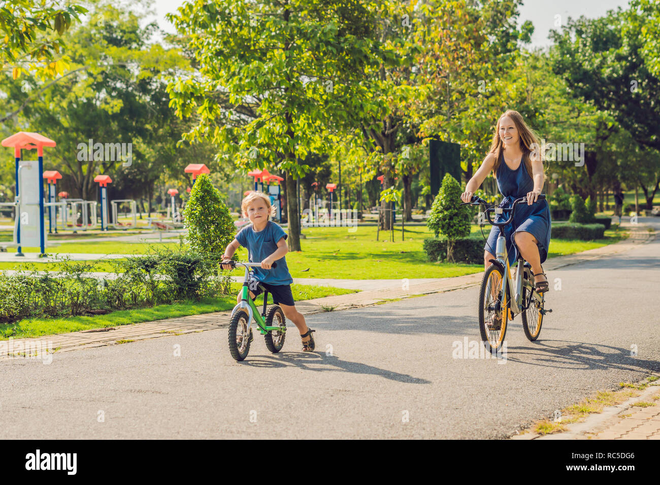 Happy family is riding bikes outdoors and smiling. Mom on a bike and ...
