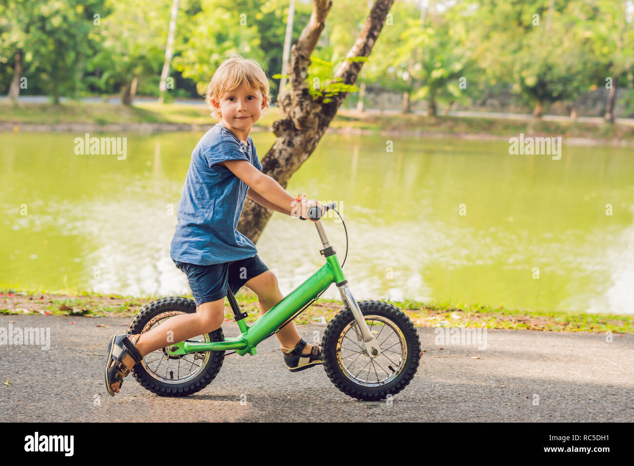 Little boy on a bicycle. Caught in motion, on a driveway. Preschool ...