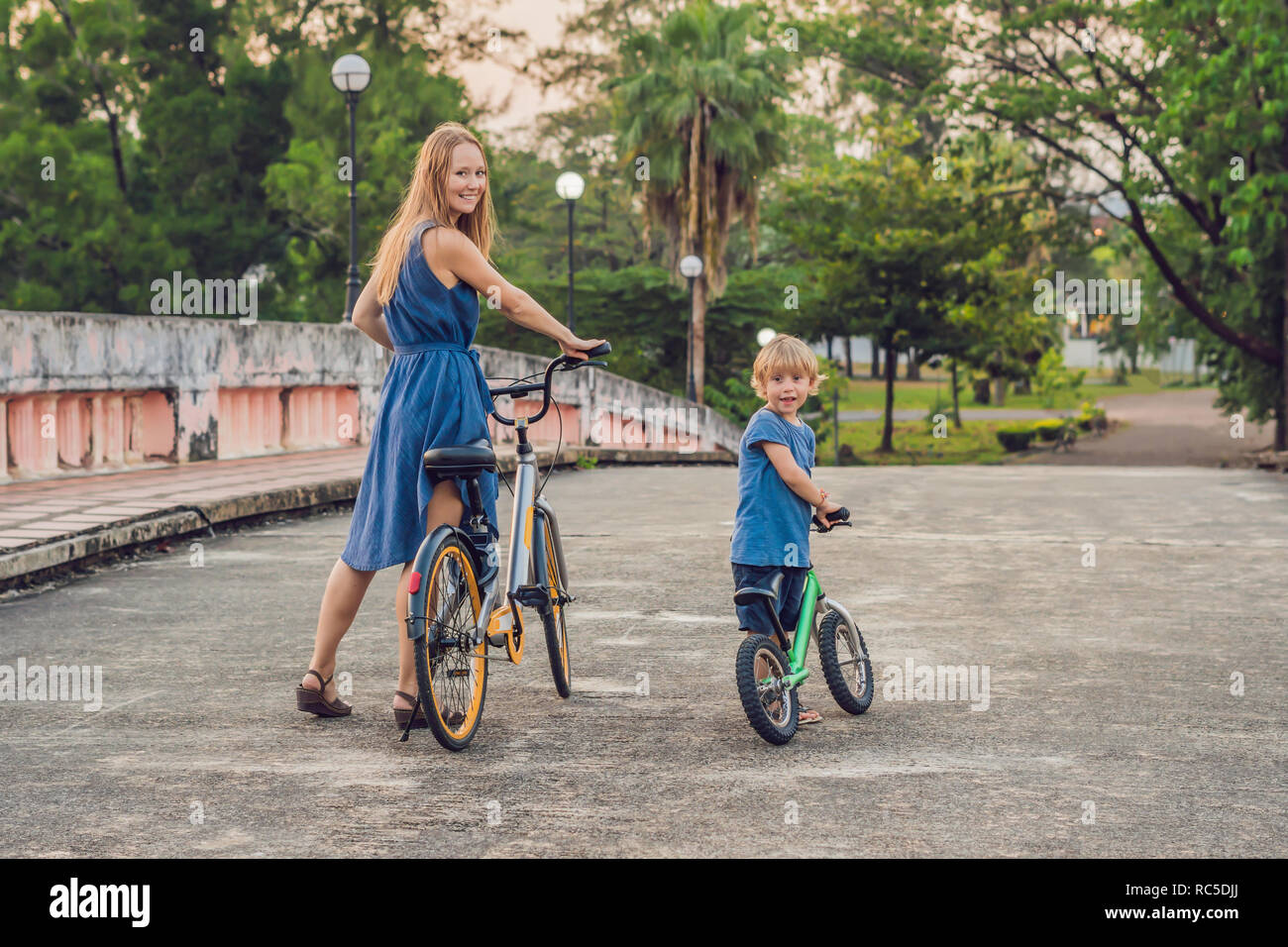 Happy family is riding bikes outdoors and smiling. Mom on a bike and ...
