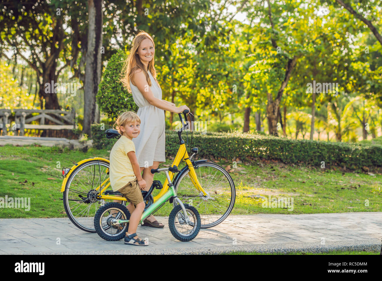 Happy family is riding bikes outdoors and smiling. Mom on a bike and ...