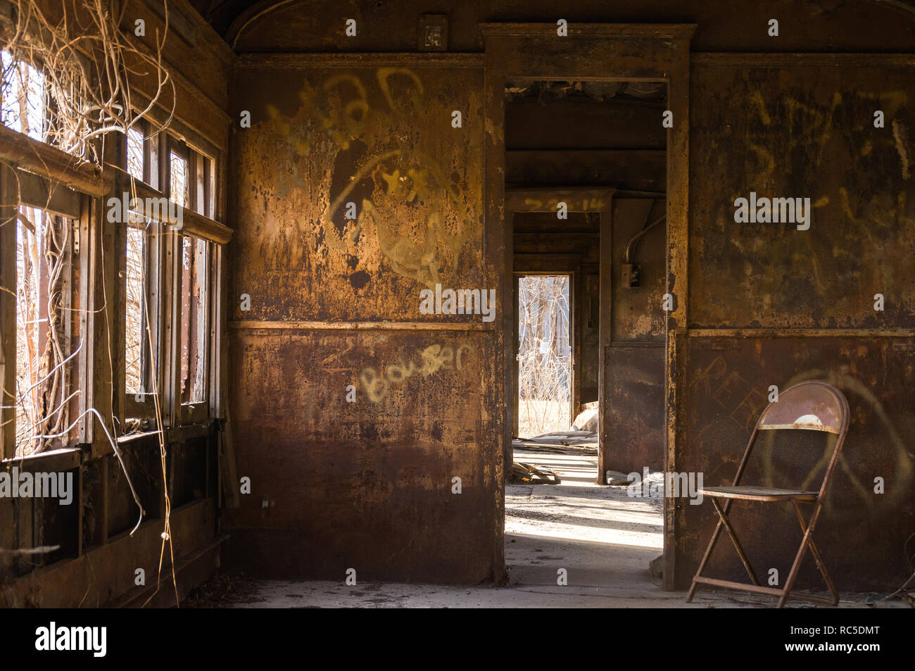 Interior of rusted vintage rail car with natural light coming through ...