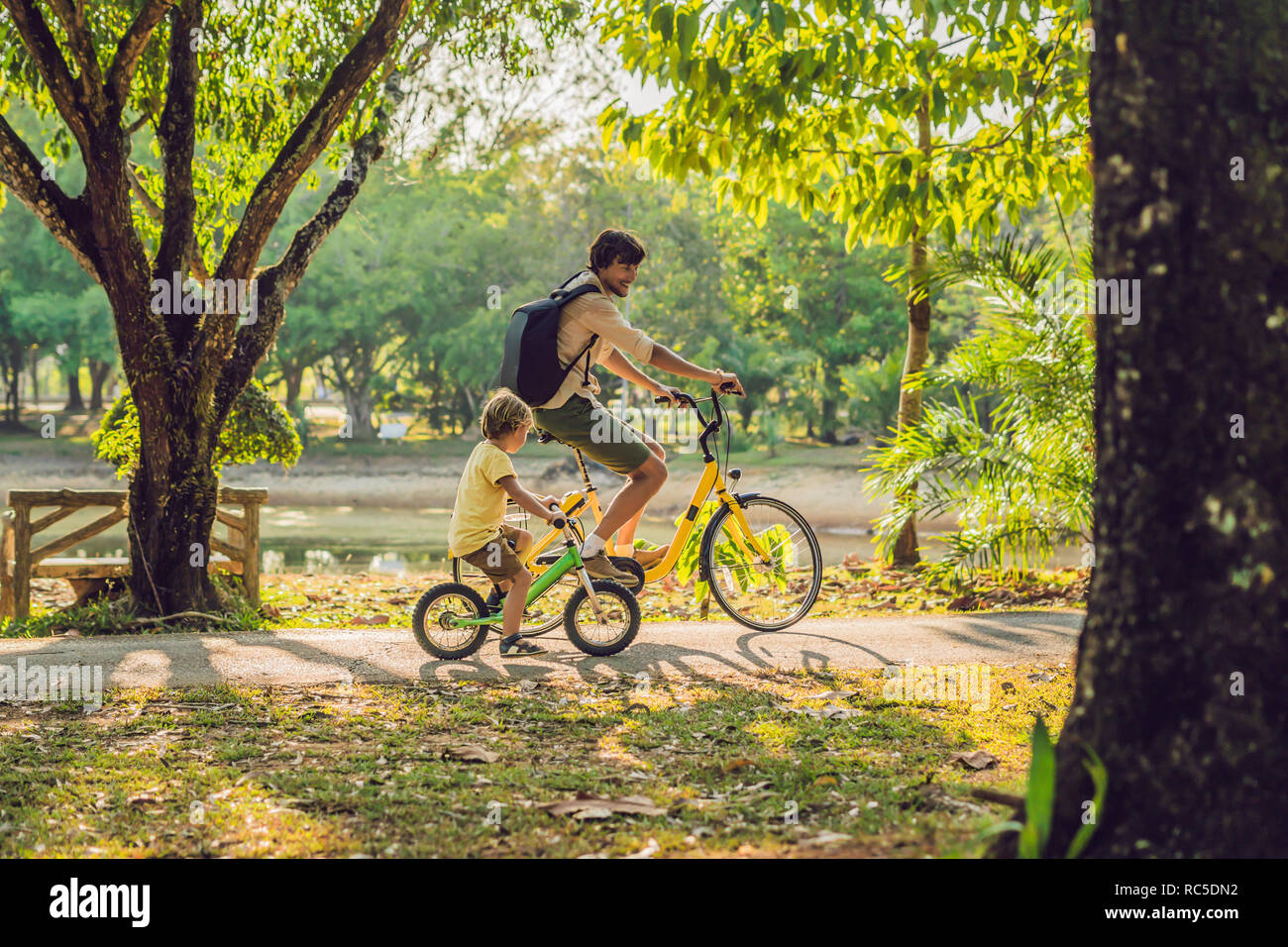 Happy family is riding bikes outdoors and smiling. Father on a bike and ...