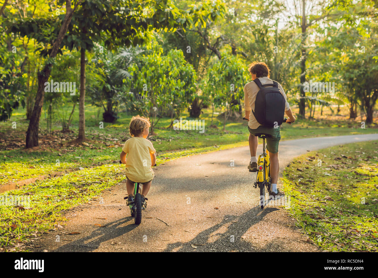 Happy family is riding bikes outdoors and smiling. Father on a bike and ...