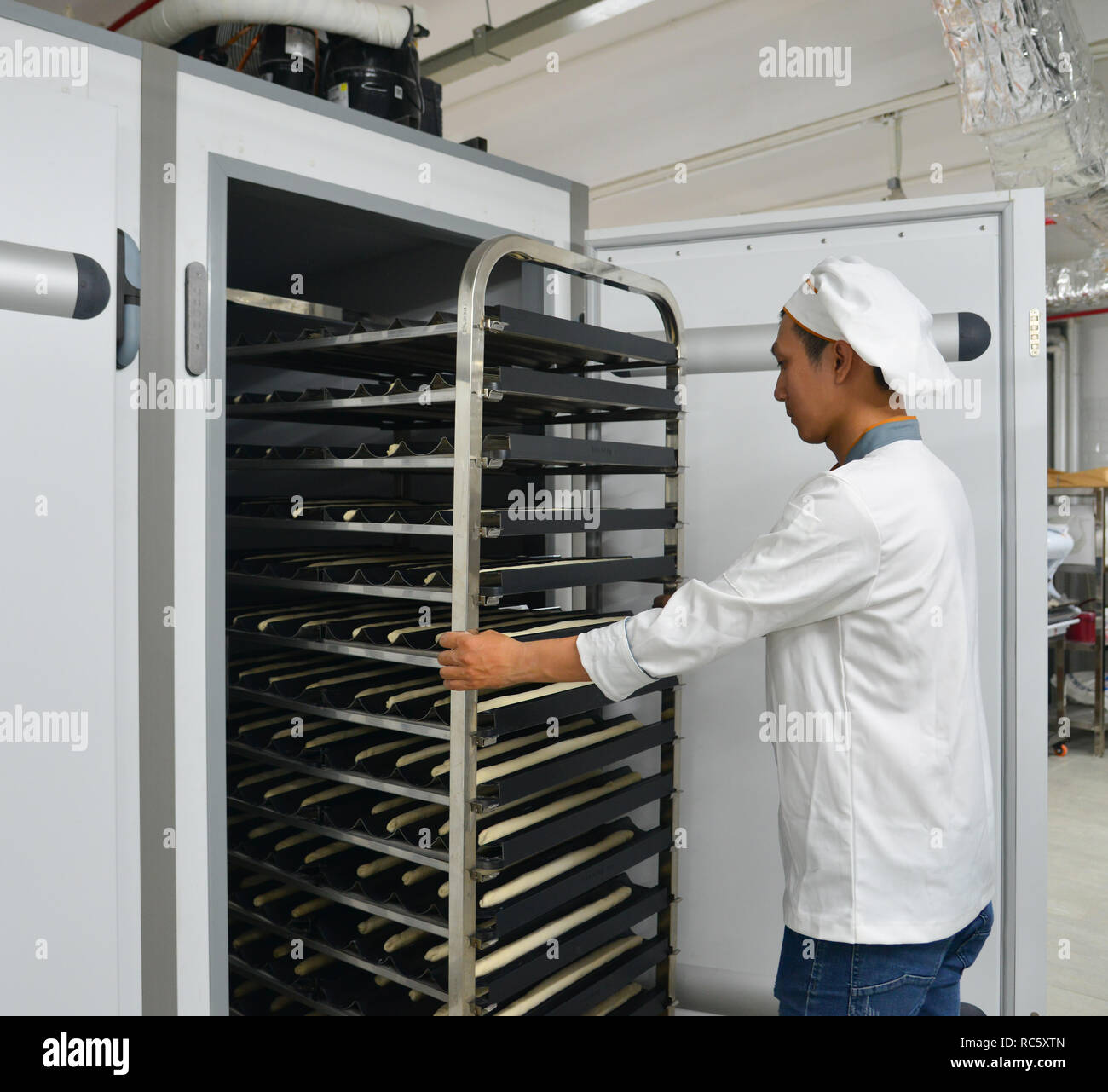 Saigon, Vietnam - Jan 9, 2018. A man working with racks of freshly ...