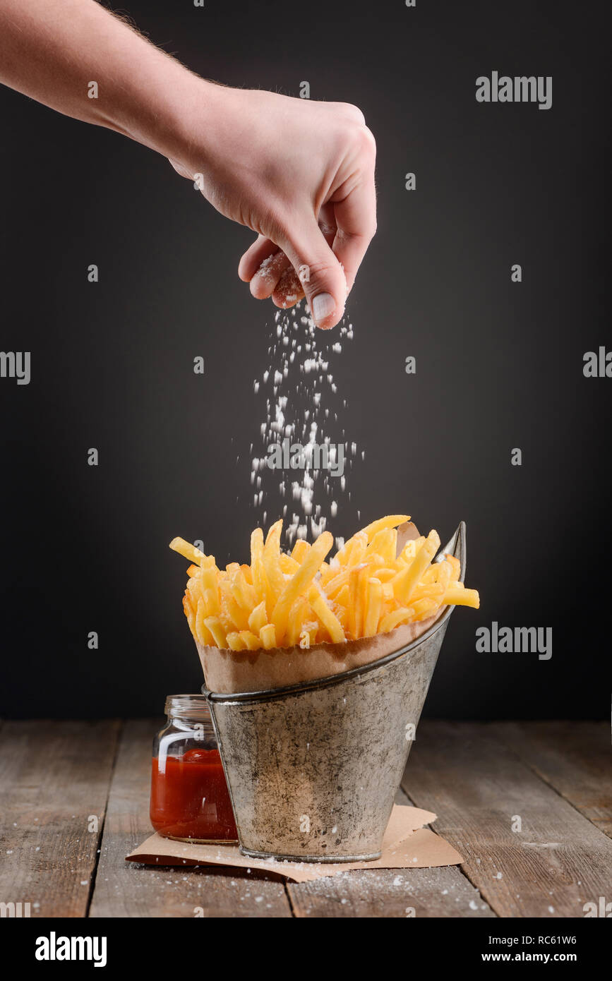 Hand adding a pinch of salt Stock Photo - Alamy