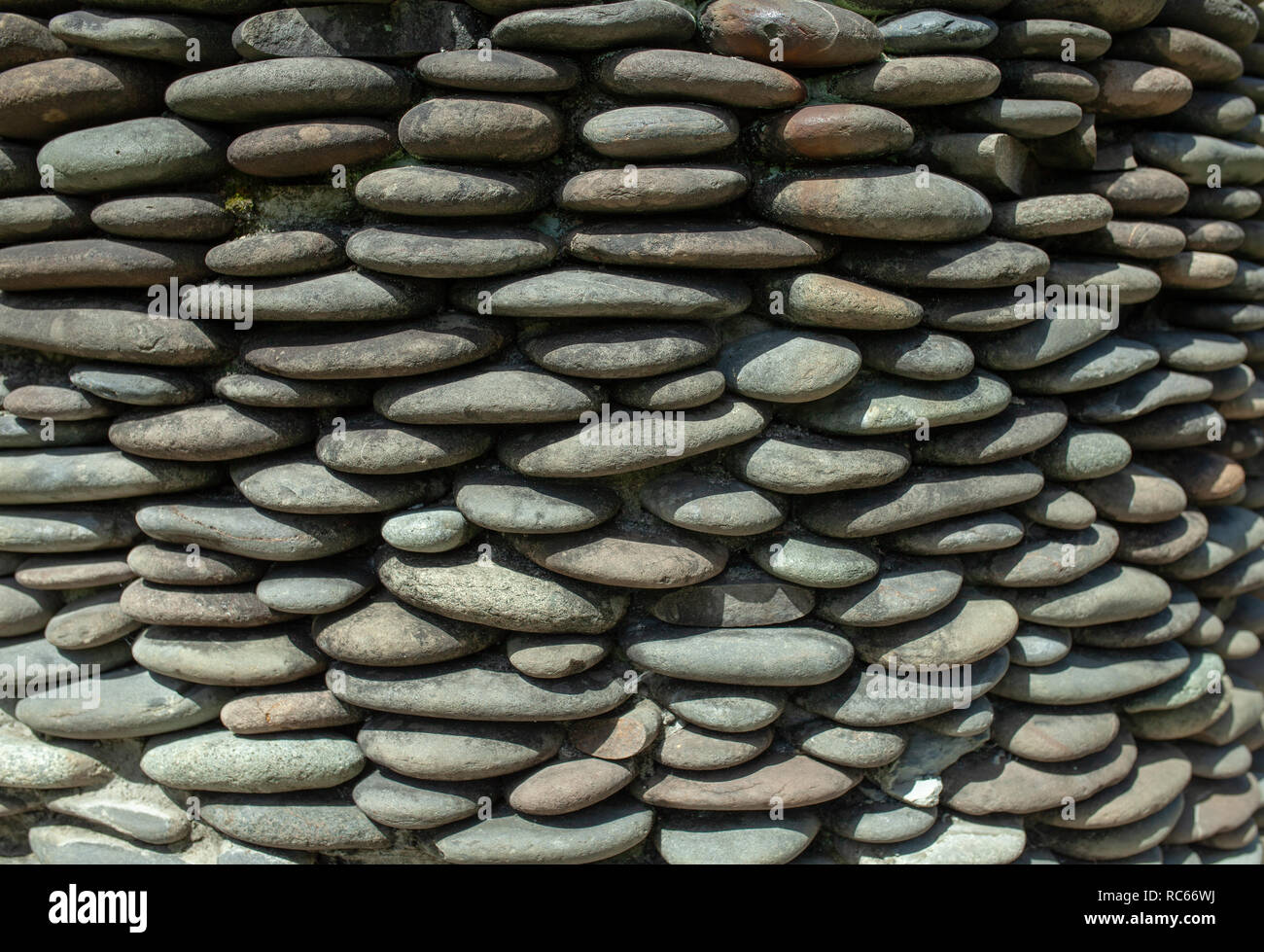 River pebble gravel round stone wall patterned for background. Gray ...