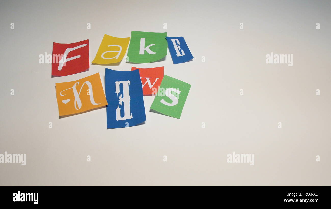 written fake news, made with pieces of newspaper is swept away by the ...