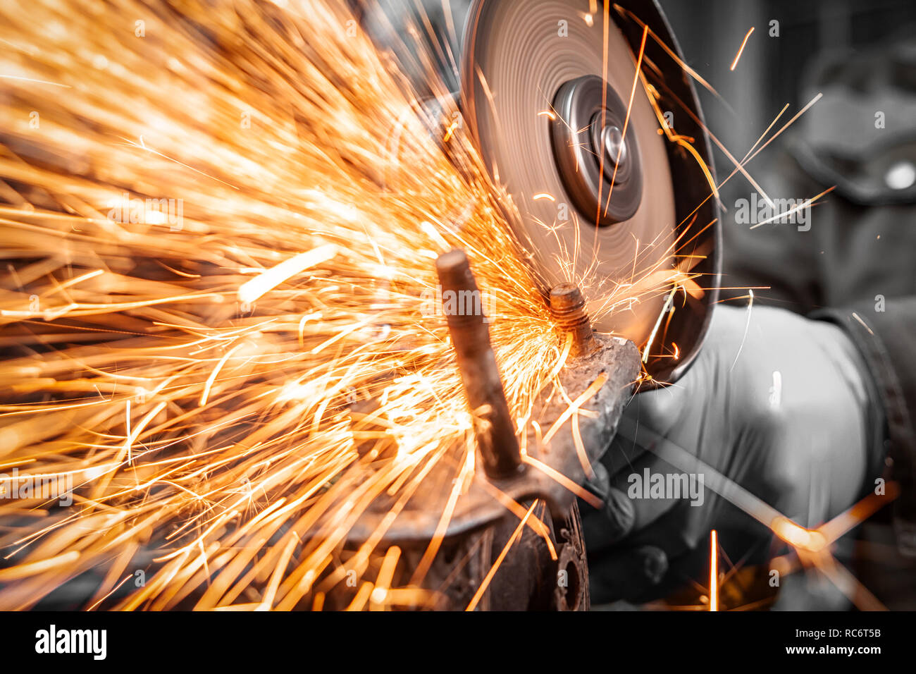 Close-up of a man sawing bearing metal with a hand circular saw, bright ...