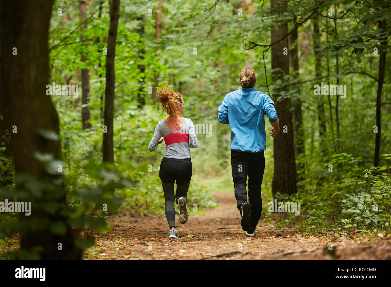 Jogging on forest path Stock Photo - Alamy