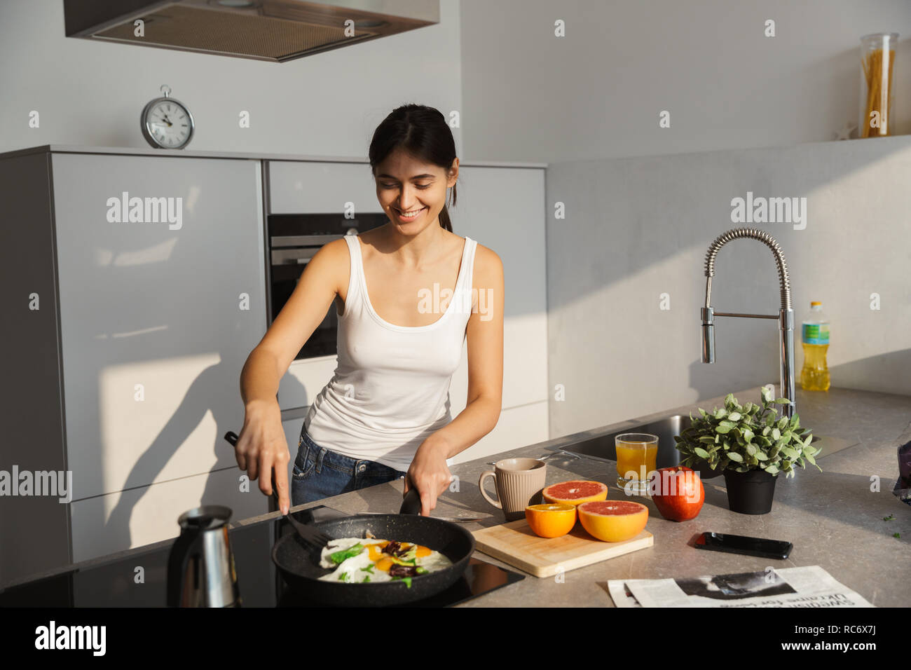 Image of an amazing happy healthy woman in the kitchen standing daily ...