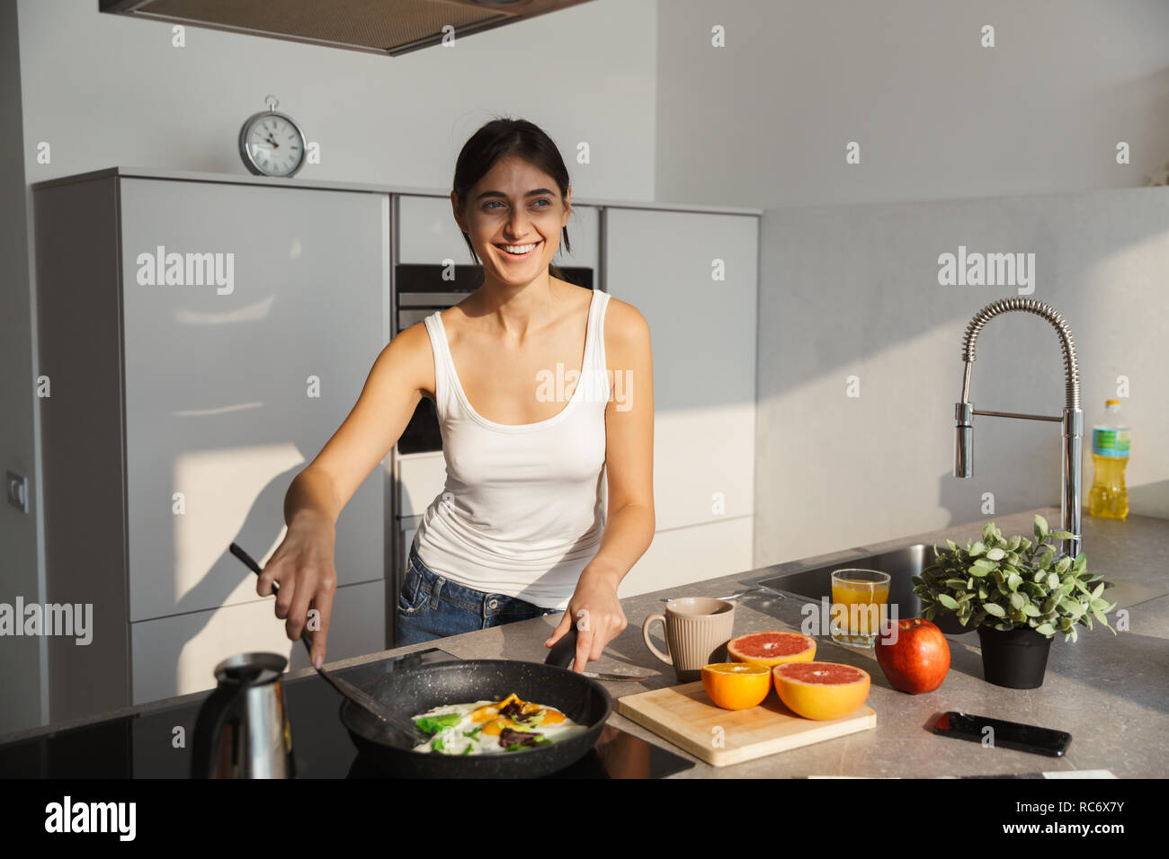 Image of an amazing happy healthy woman in the kitchen standing daily ...