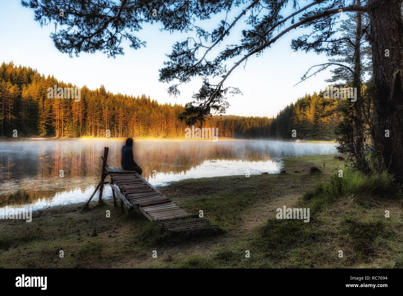 man is watching sunset at mountain lake Stock Photo - Alamy