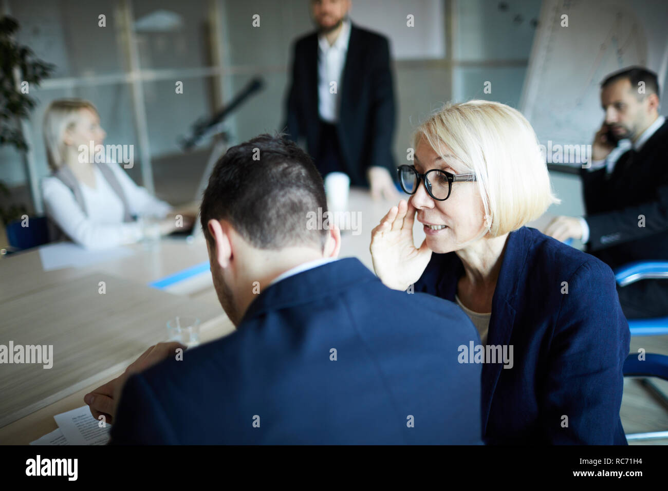 Woman whispering colleague conference hi-res stock photography and ...