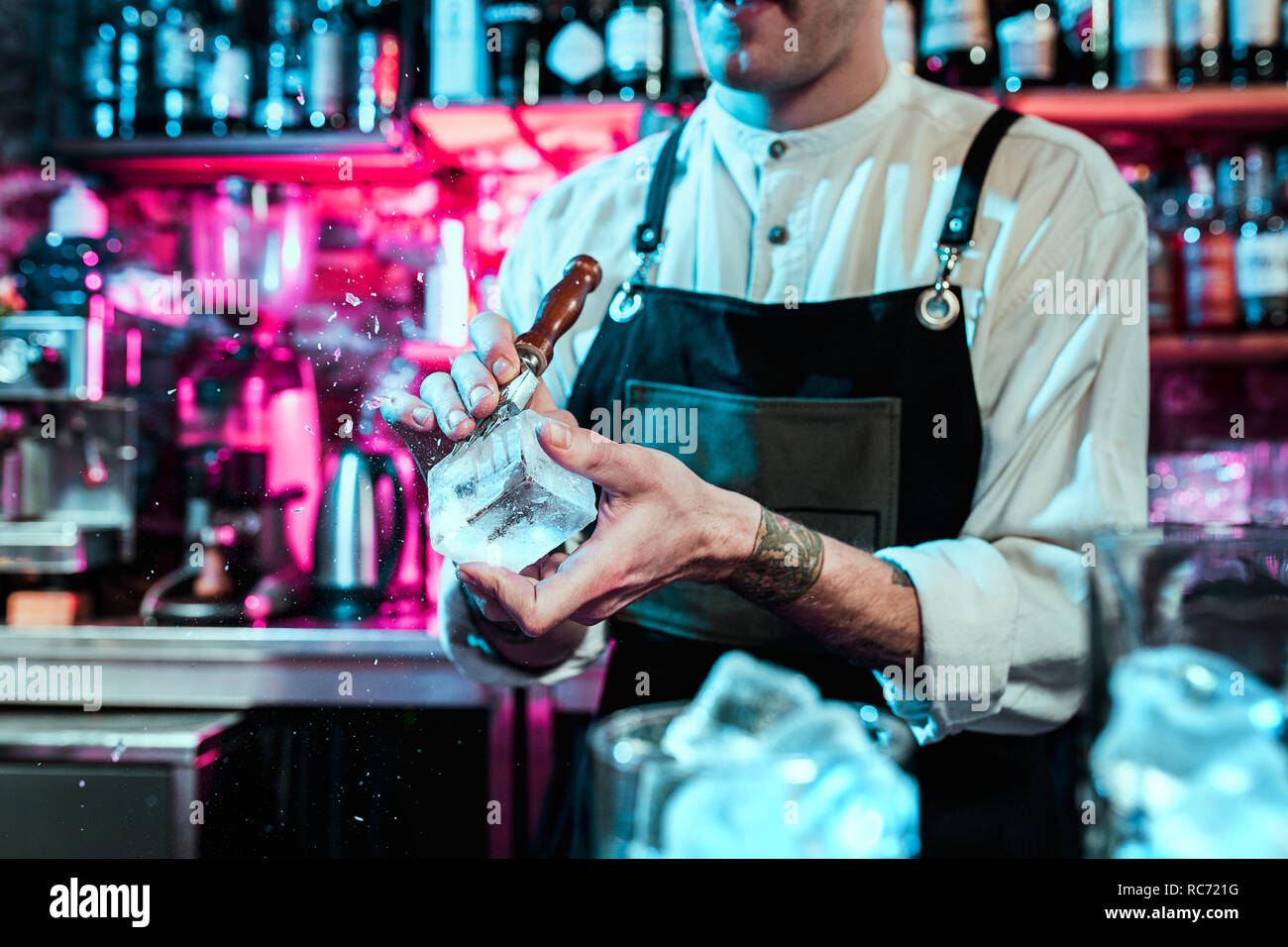 Expert barman is making cocktail at night club or bar. Glass of fiery ...