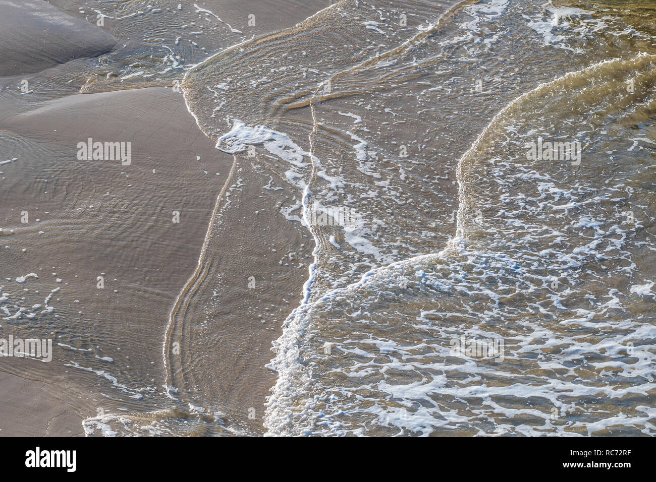 Incoming tide on a beach Stock Photo - Alamy