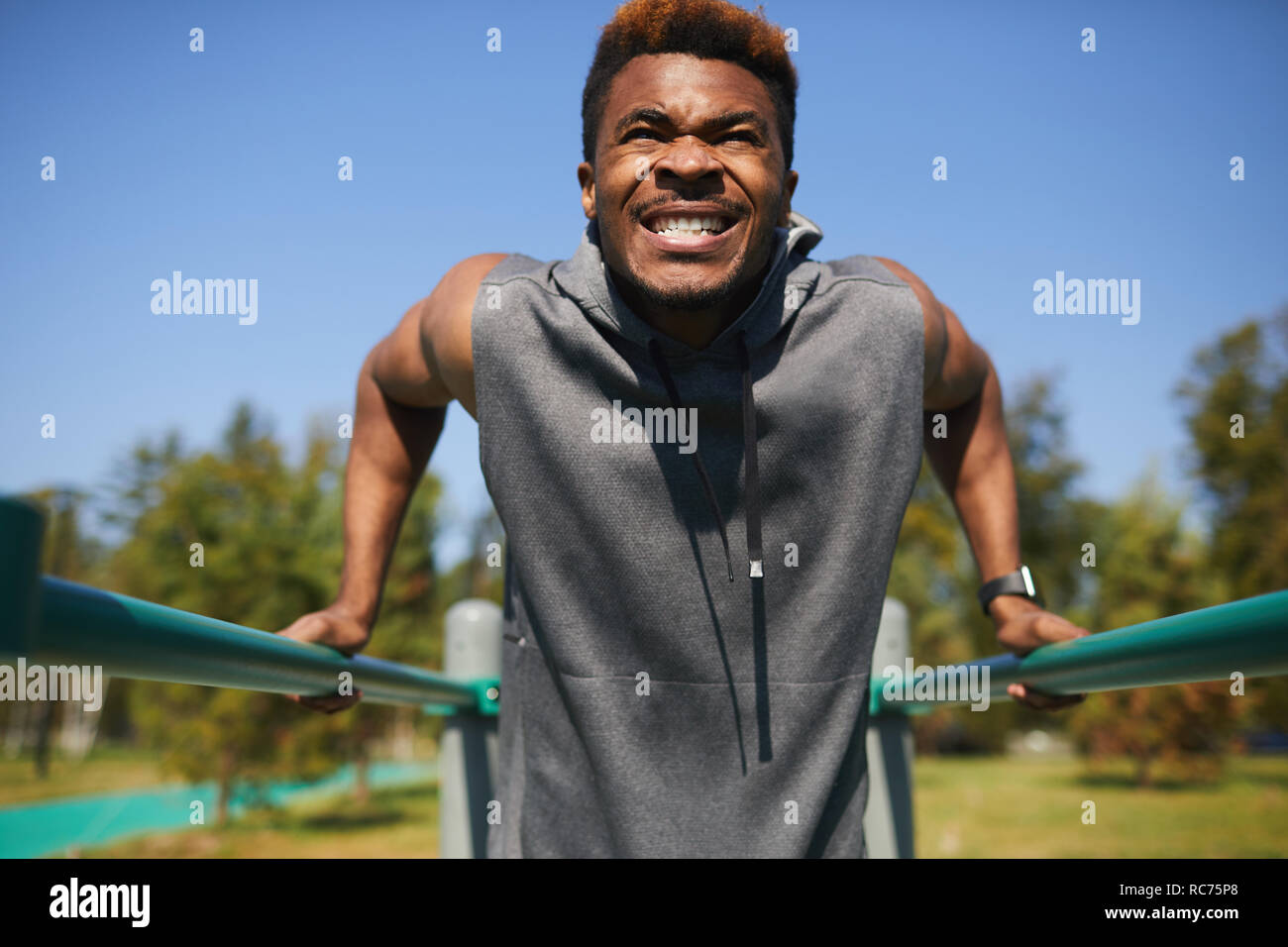 Black man with clenched teeth doing dips Stock Photo - Alamy