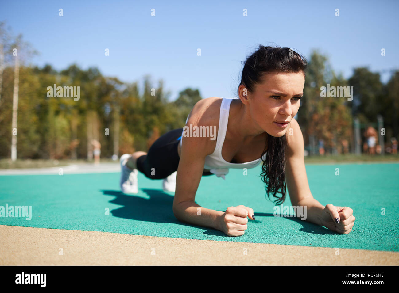 Concentrated lady doing plank at stadium Stock Photo - Alamy