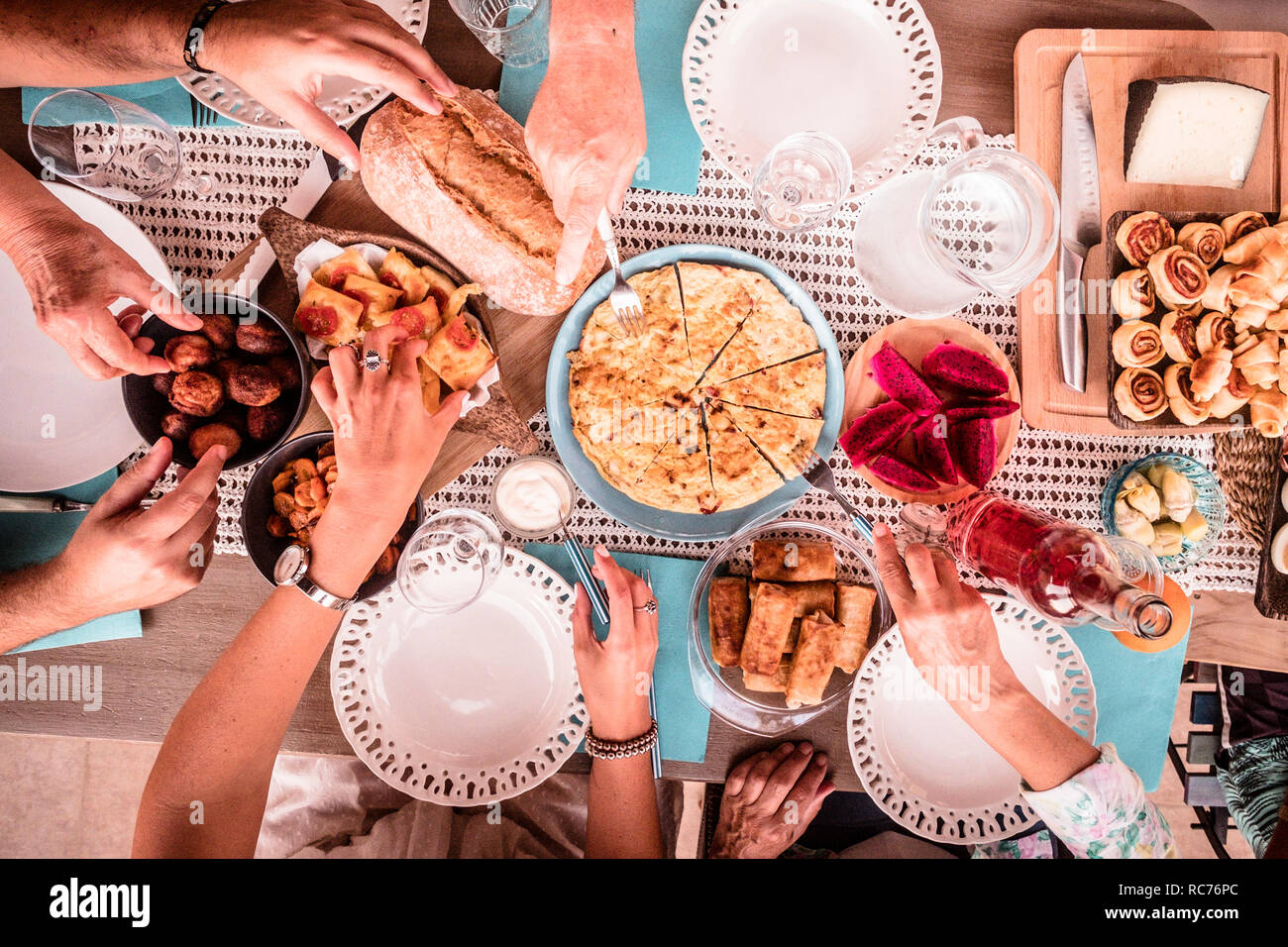 Top view of colorful table full of mixed culture food and hands and ...