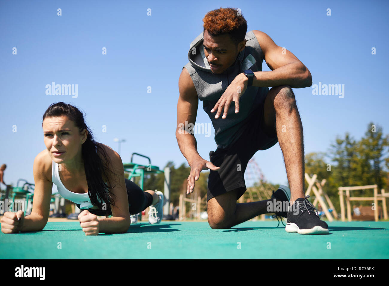 Fitness coach supporting trainee at stadium Stock Photo - Alamy