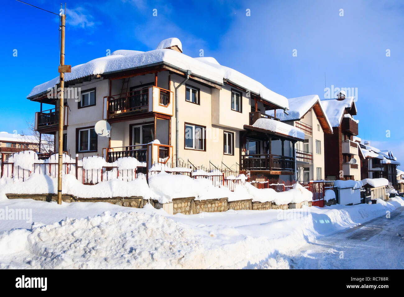 Street view, traditional houses and high snow in bulgarian ski resort ...