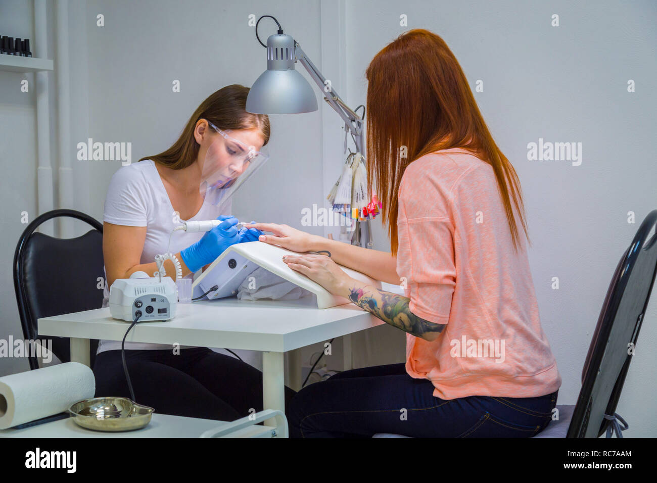 Hardware manicure in a beauty salon. Manicurist is applying electric ...