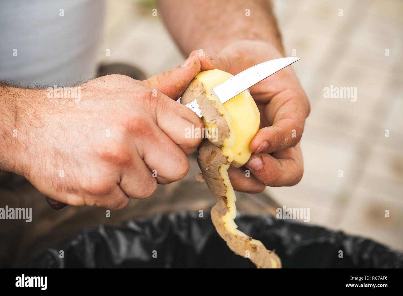 Raw potato peel. Hands of cook and knife, close-up photo, selective ...