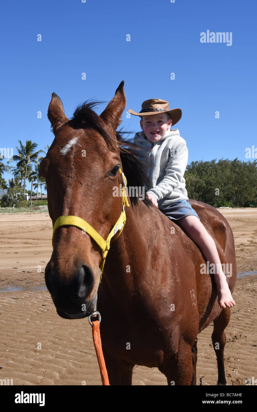 Young boy horse riding on Sarina Beach Stock Photo - Alamy