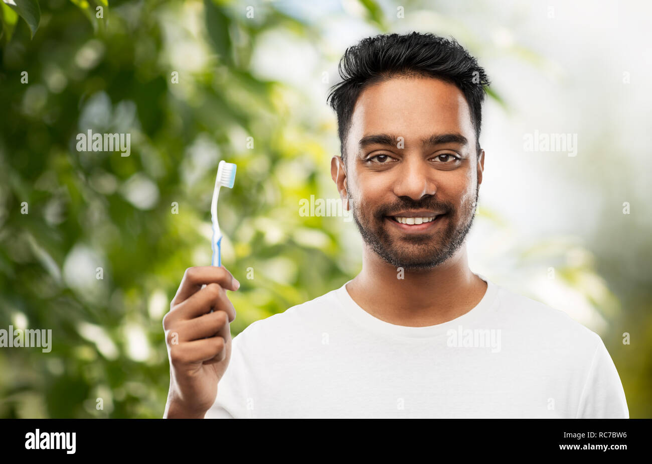 indian man with toothbrush over natural background Stock Photo - Alamy