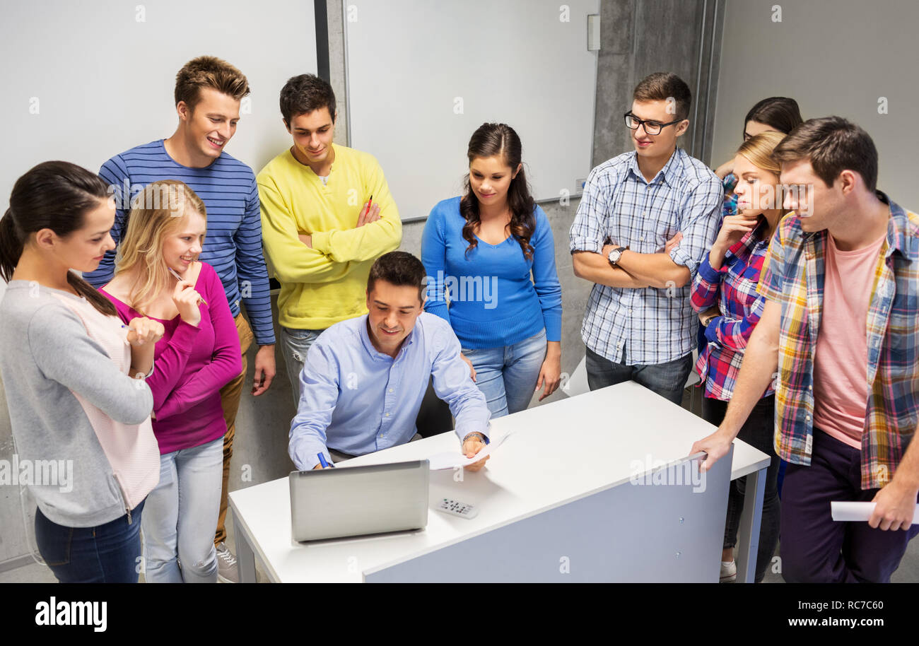 students and teacher with papers and laptop Stock Photo - Alamy