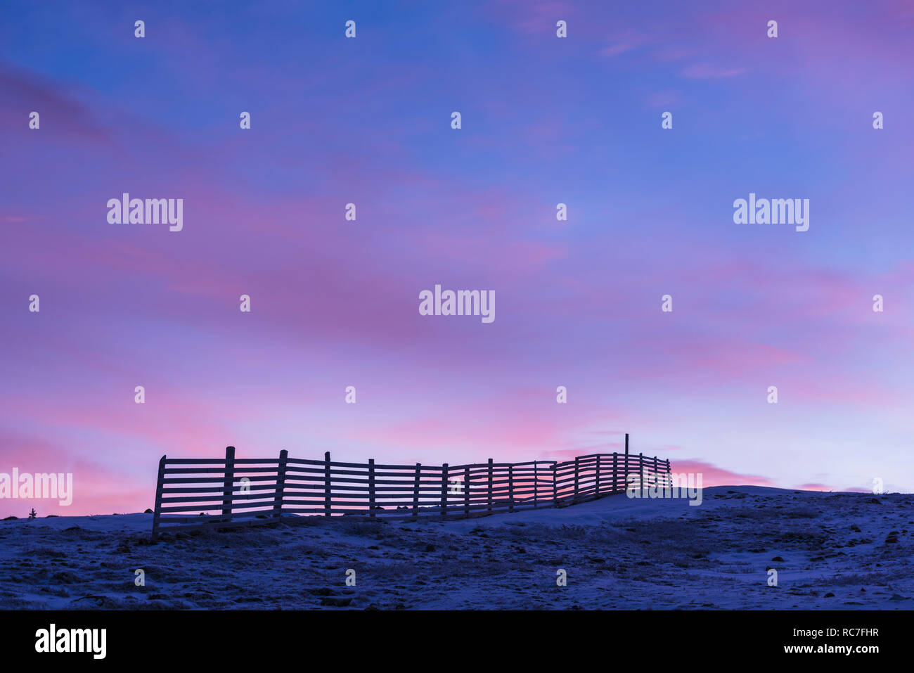 Winter landscape with fence at dawn Stock Photo - Alamy