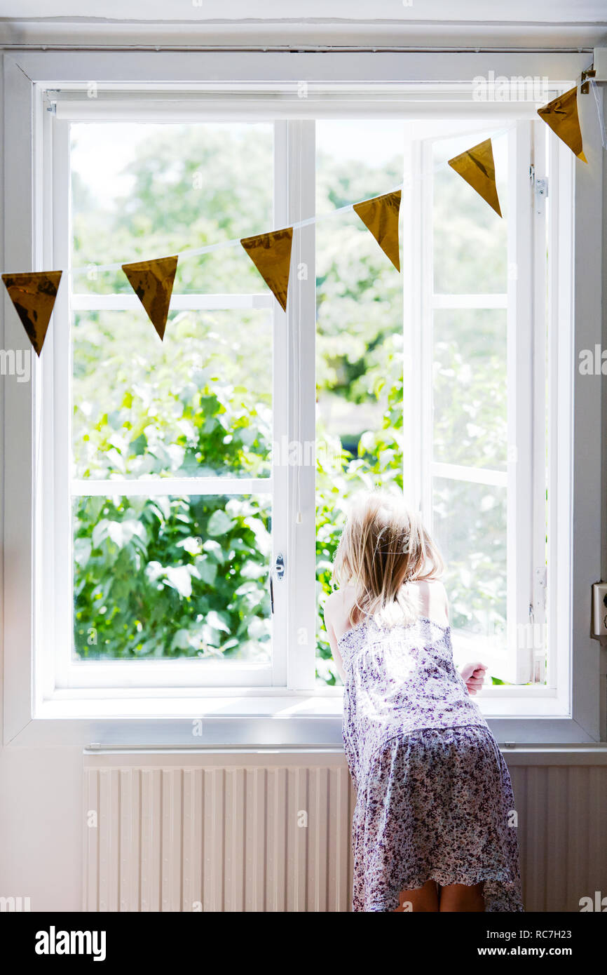 Girl looking through window Stock Photo - Alamy