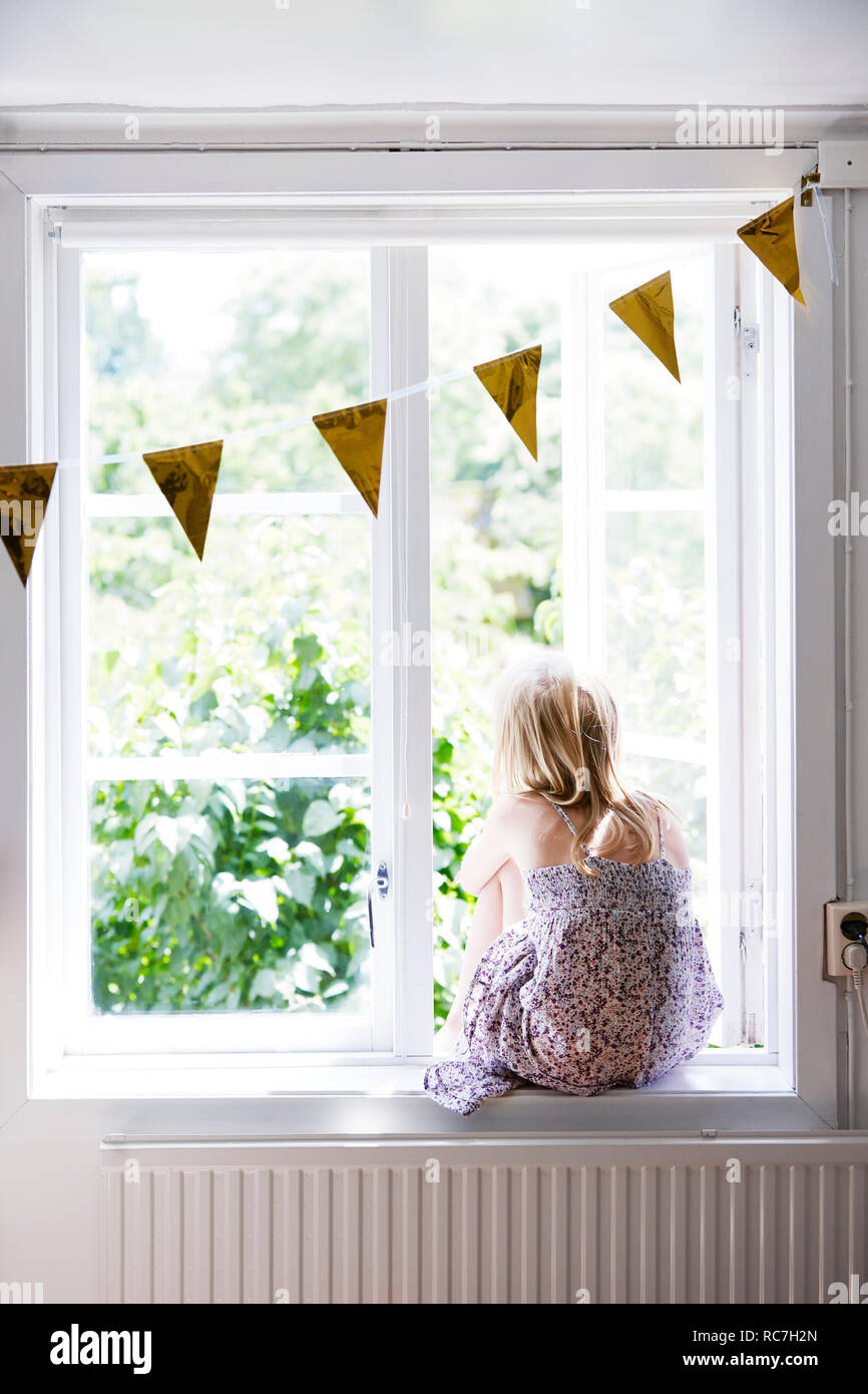 Girl looking through window Stock Photo - Alamy