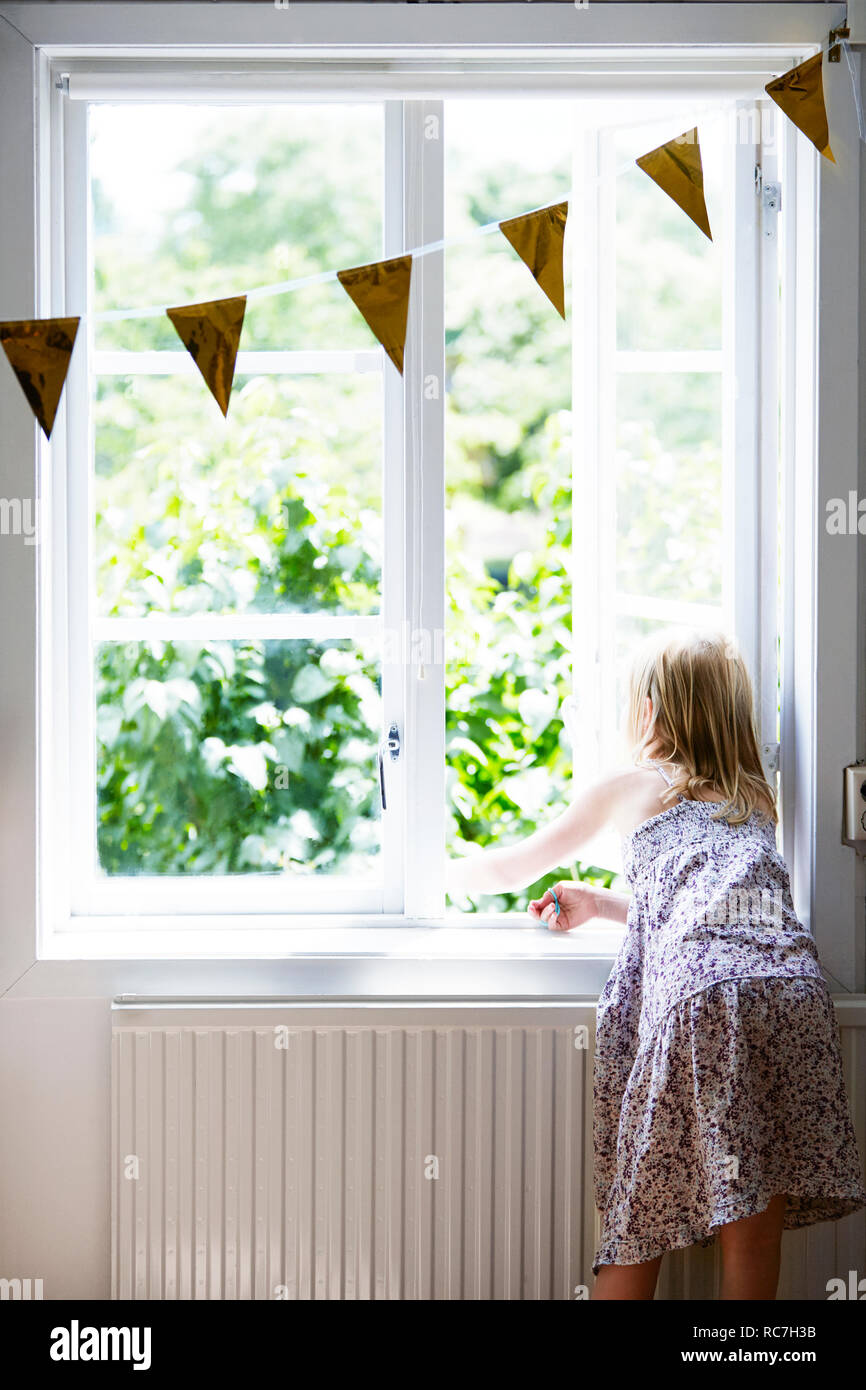 Girl looking through window Stock Photo - Alamy
