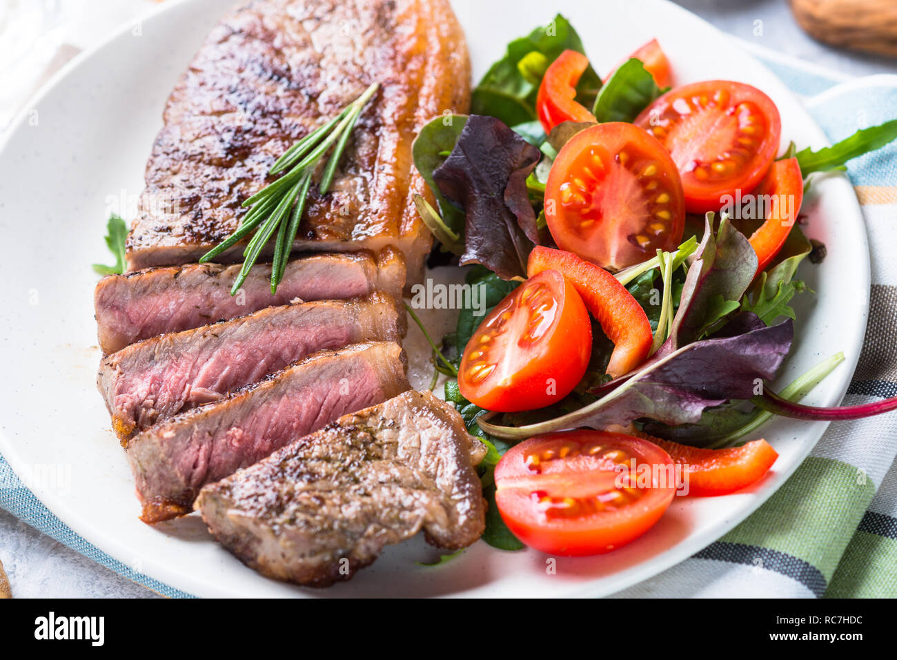Grilled beef striploin steak with fresh salad Stock Photo - Alamy