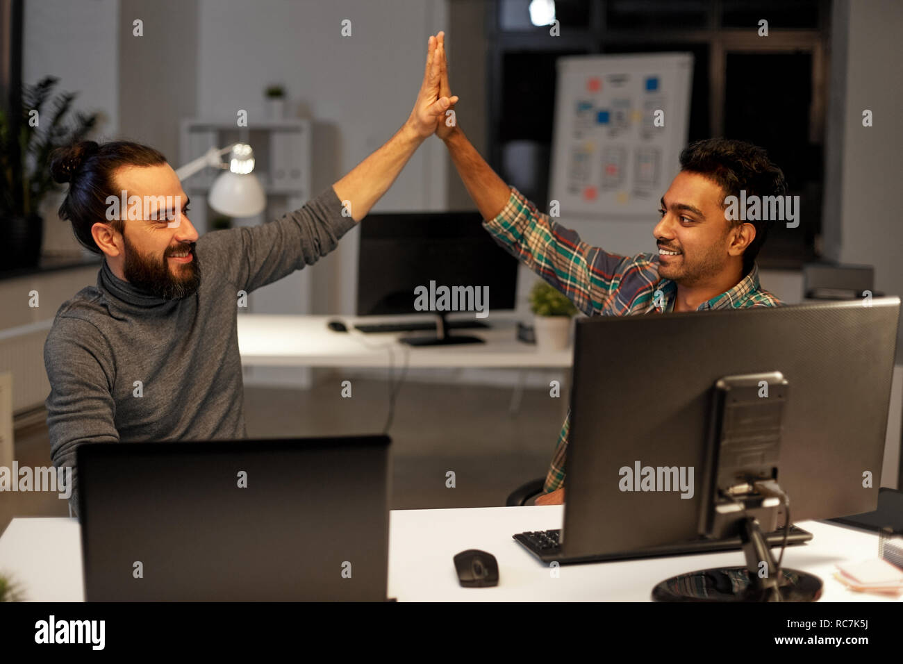 creative team making high five at night office Stock Photo - Alamy