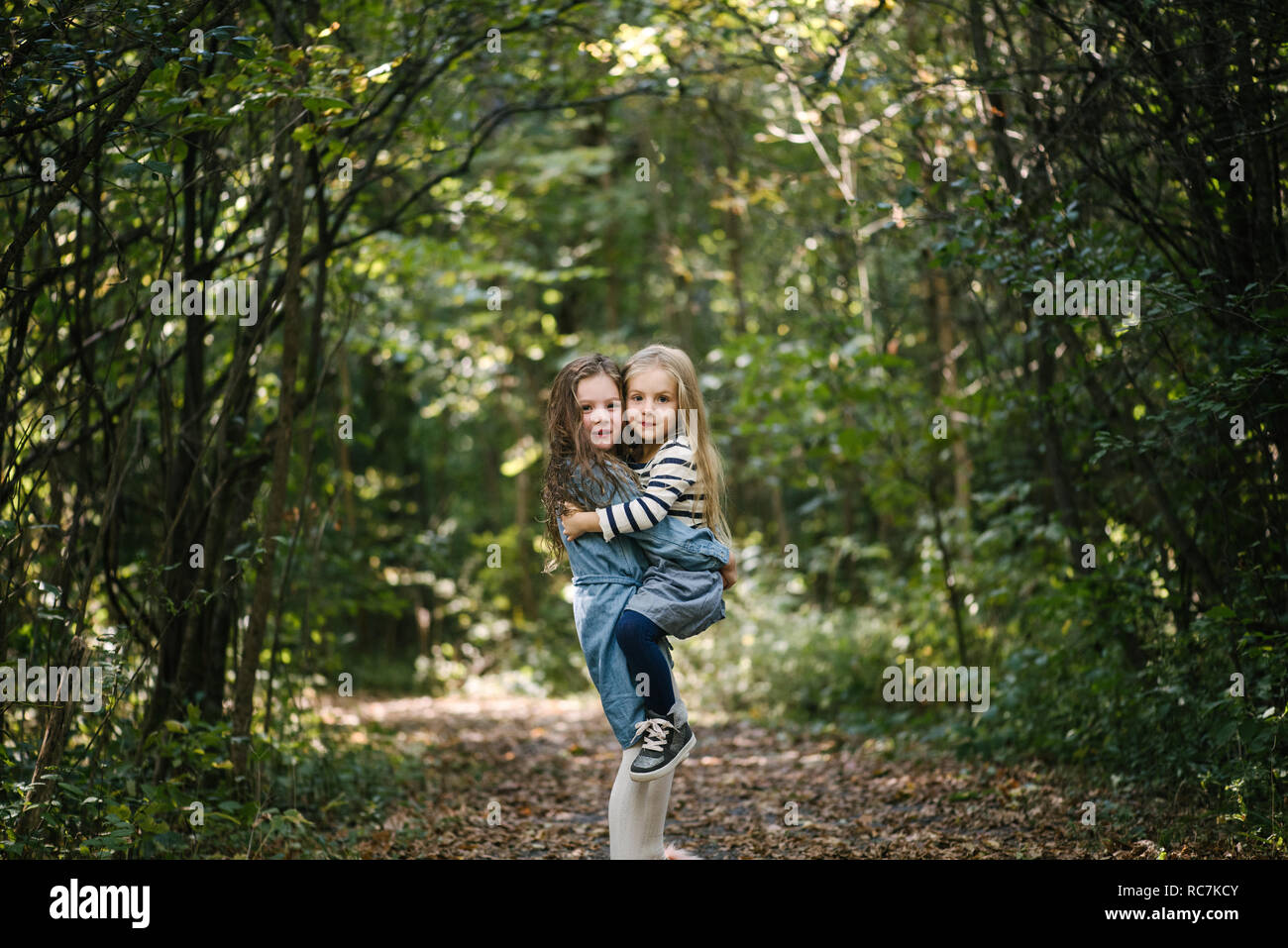 Sisters hugging in forest Stock Photo - Alamy