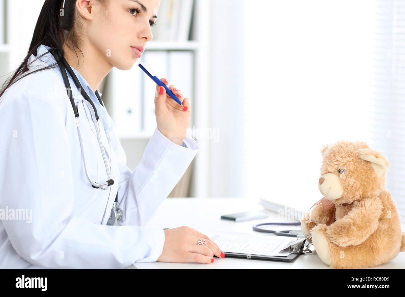 Doctor and patient baby in hospital. Little girl is being examined by ...