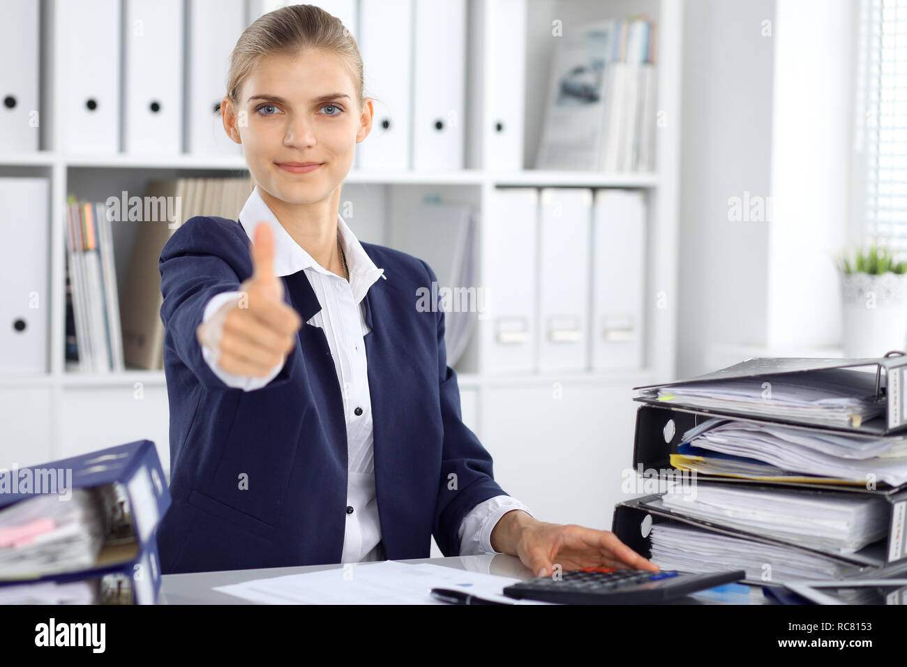 Modern business woman or confident female accountant showing thumb up ...