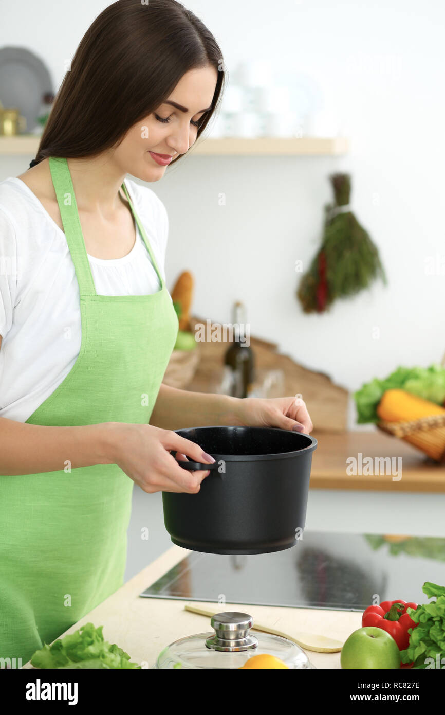 Beautiful Hispanic woman cooking soup in kitchen. Healthy meal and ...