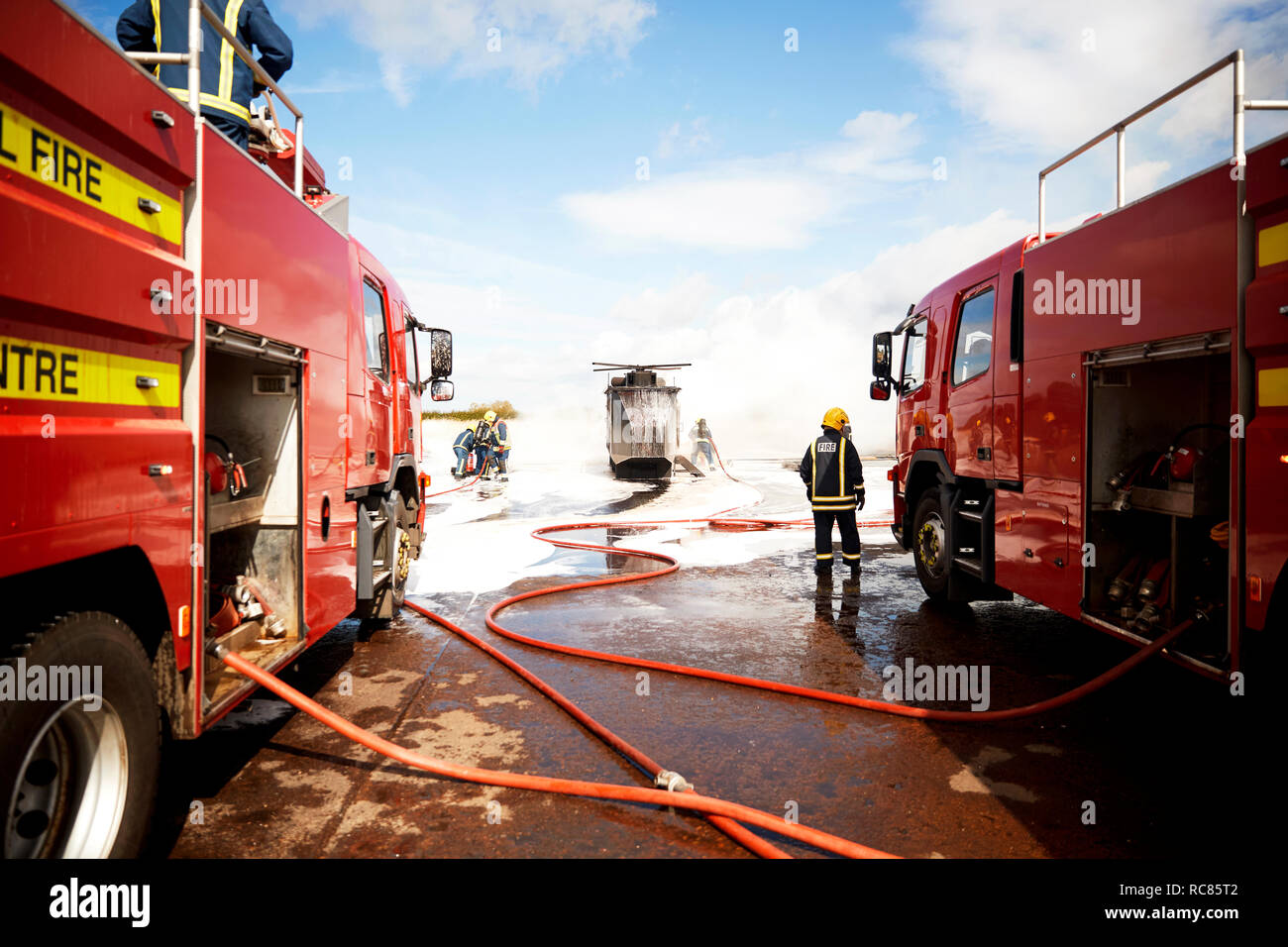 Firemen training, team of firemen spraying firefighting foam at mock ...